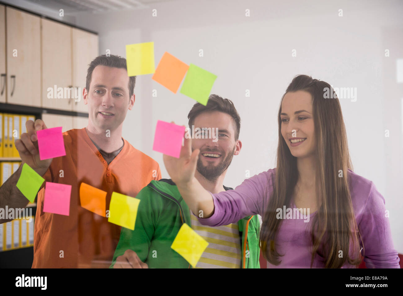 Young colleagues thinking planning using post-its Stock Photo - Alamy