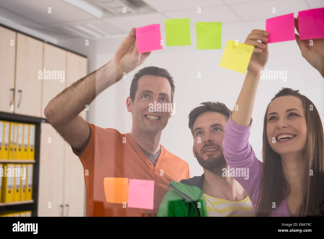 work colleagues planning playing using post-its Stock Photo - Alamy