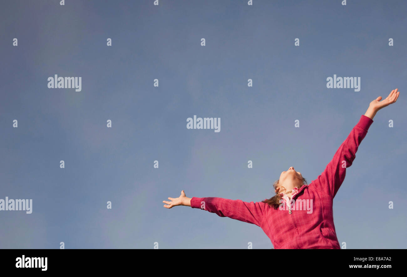Girl looking up with arms up Stock Photo - Alamy