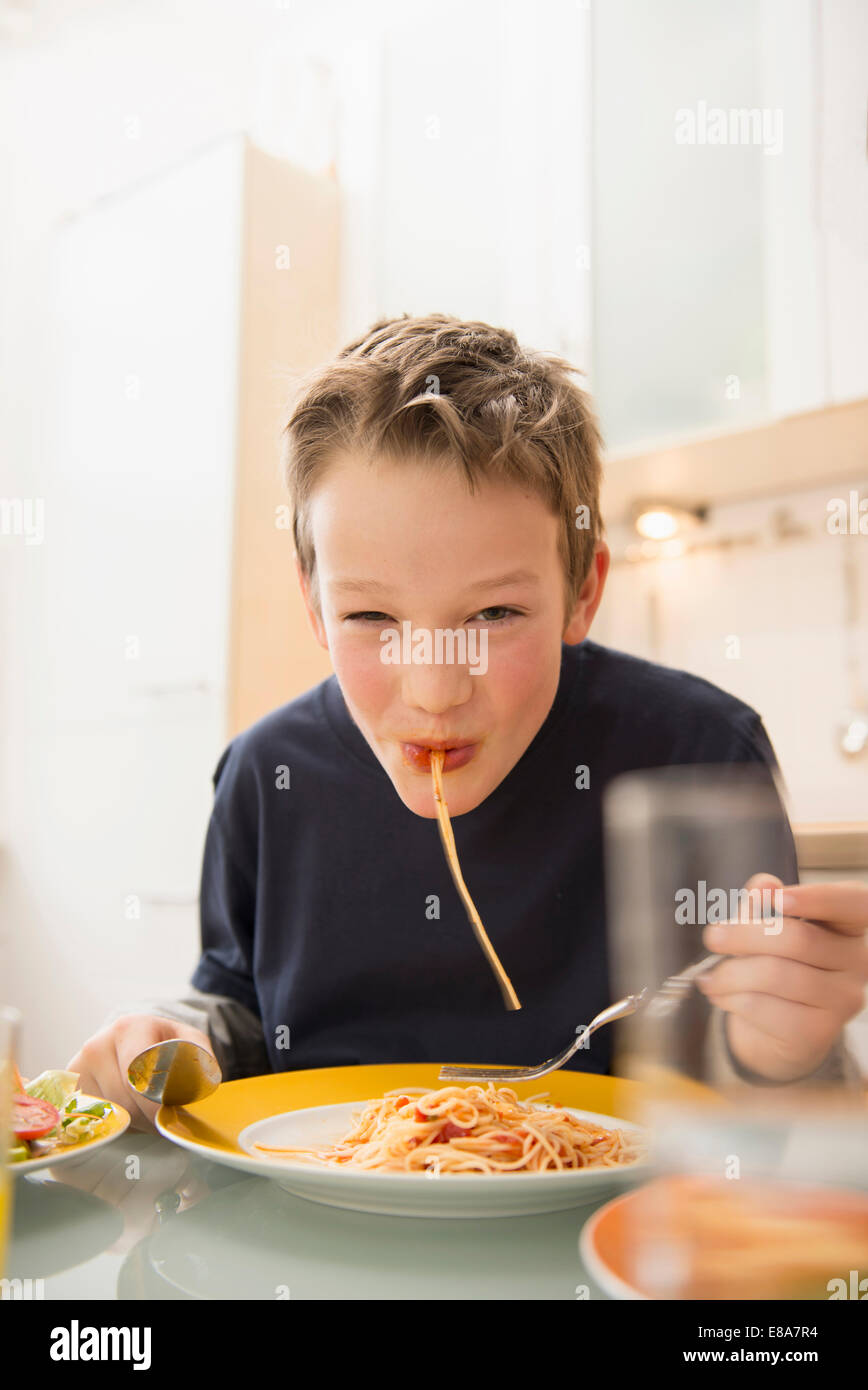 Boy eating spaghetti in kitchen Stock Photo - Alamy