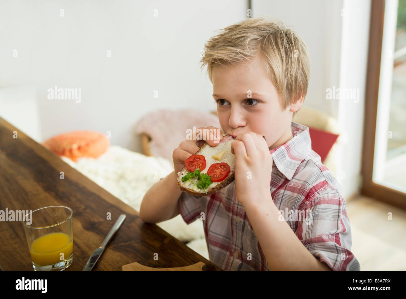 Boy biting off piece of bread and butter Stock Photo - Alamy