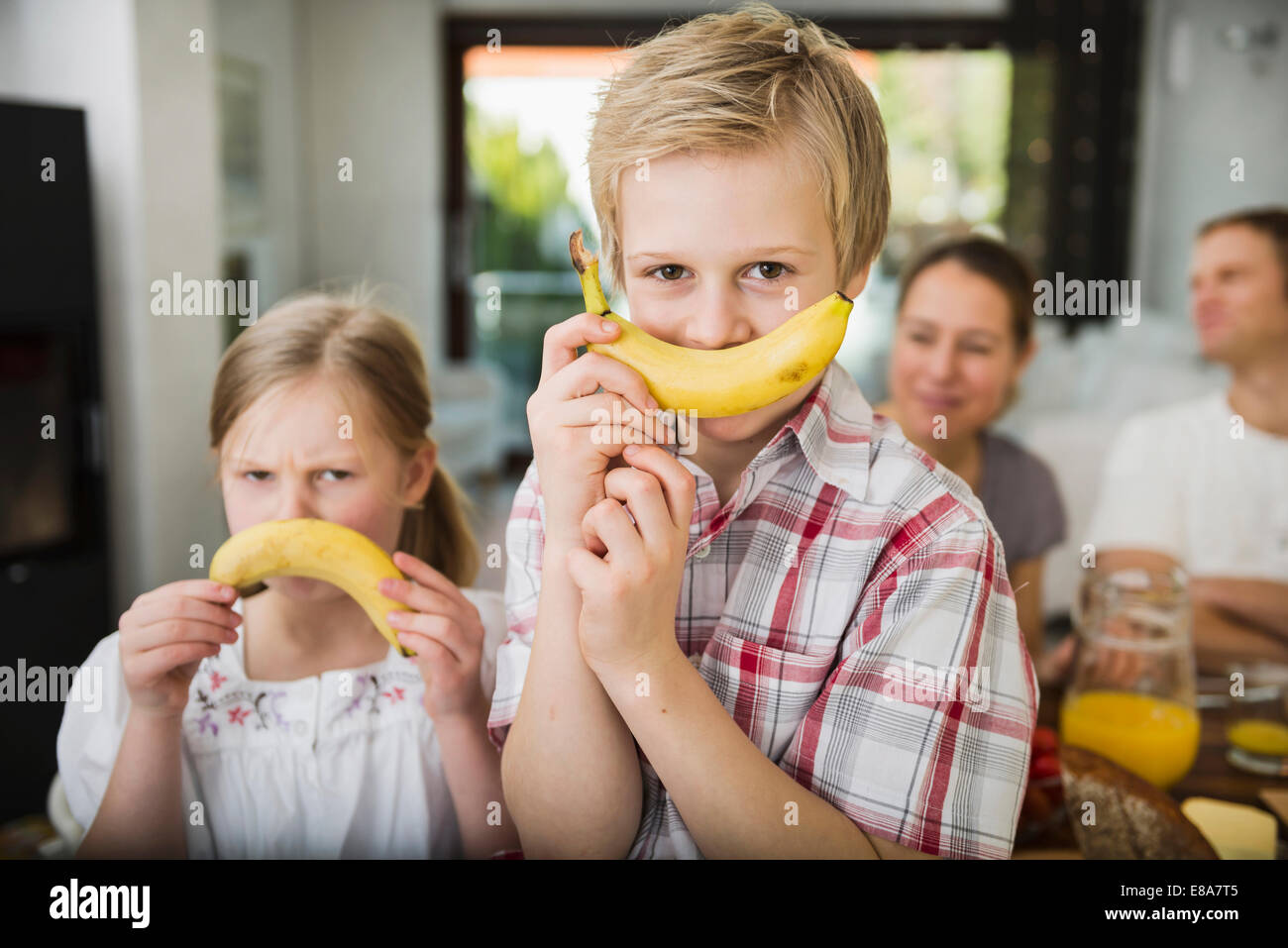 Brother and sister having fun with two bananas Stock Photo - Alamy
