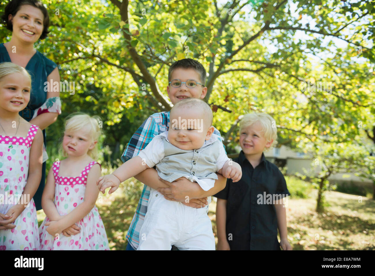 Mother and five children standing in garden Stock Photo - Alamy