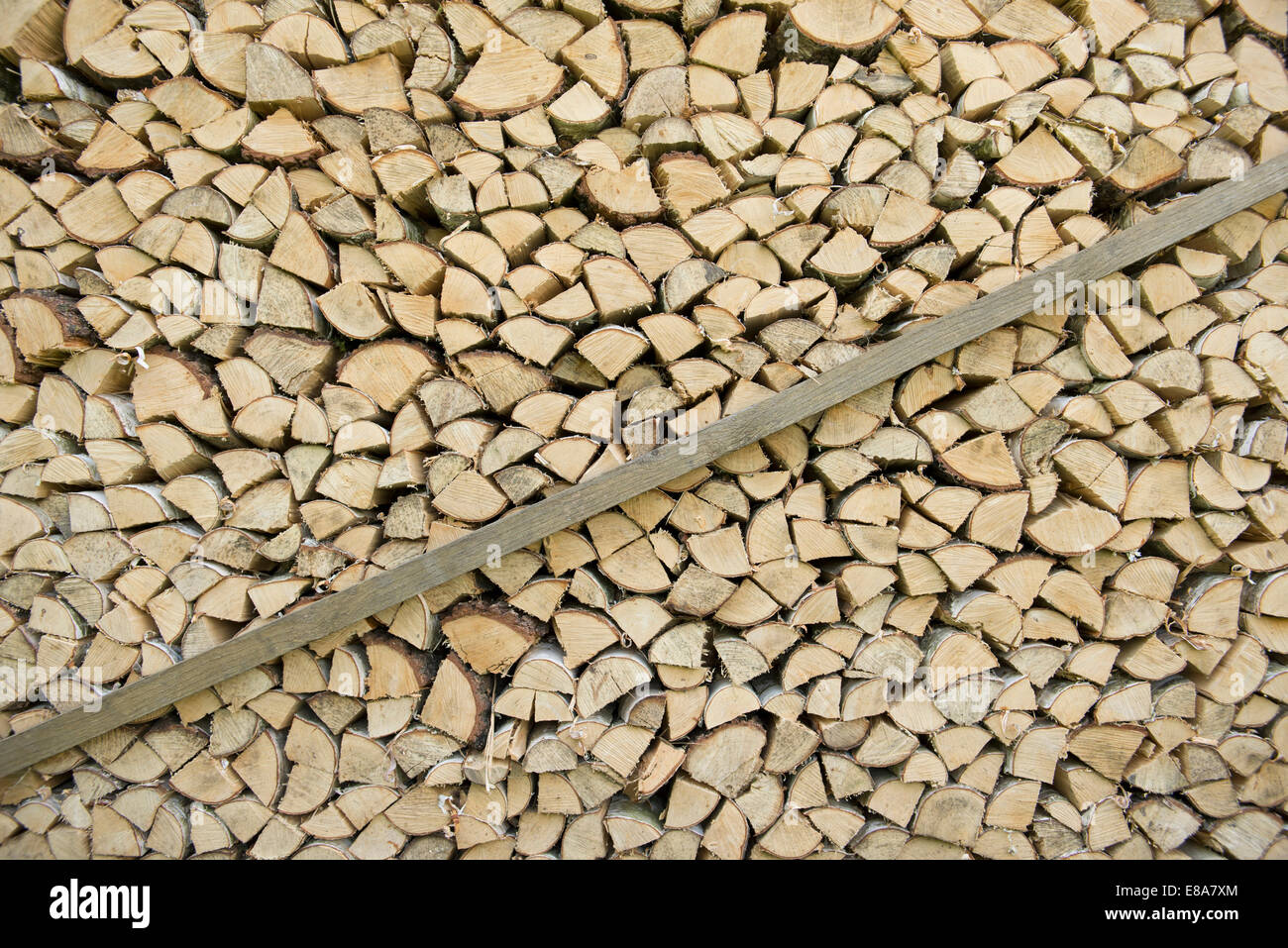 Pile of firewood stacked against wall in garden Stock Photo - Alamy