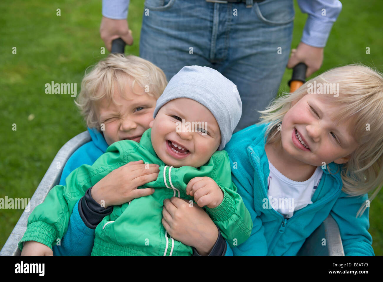 Father in garden pushing kids in wheelbarrow Stock Photo - Alamy