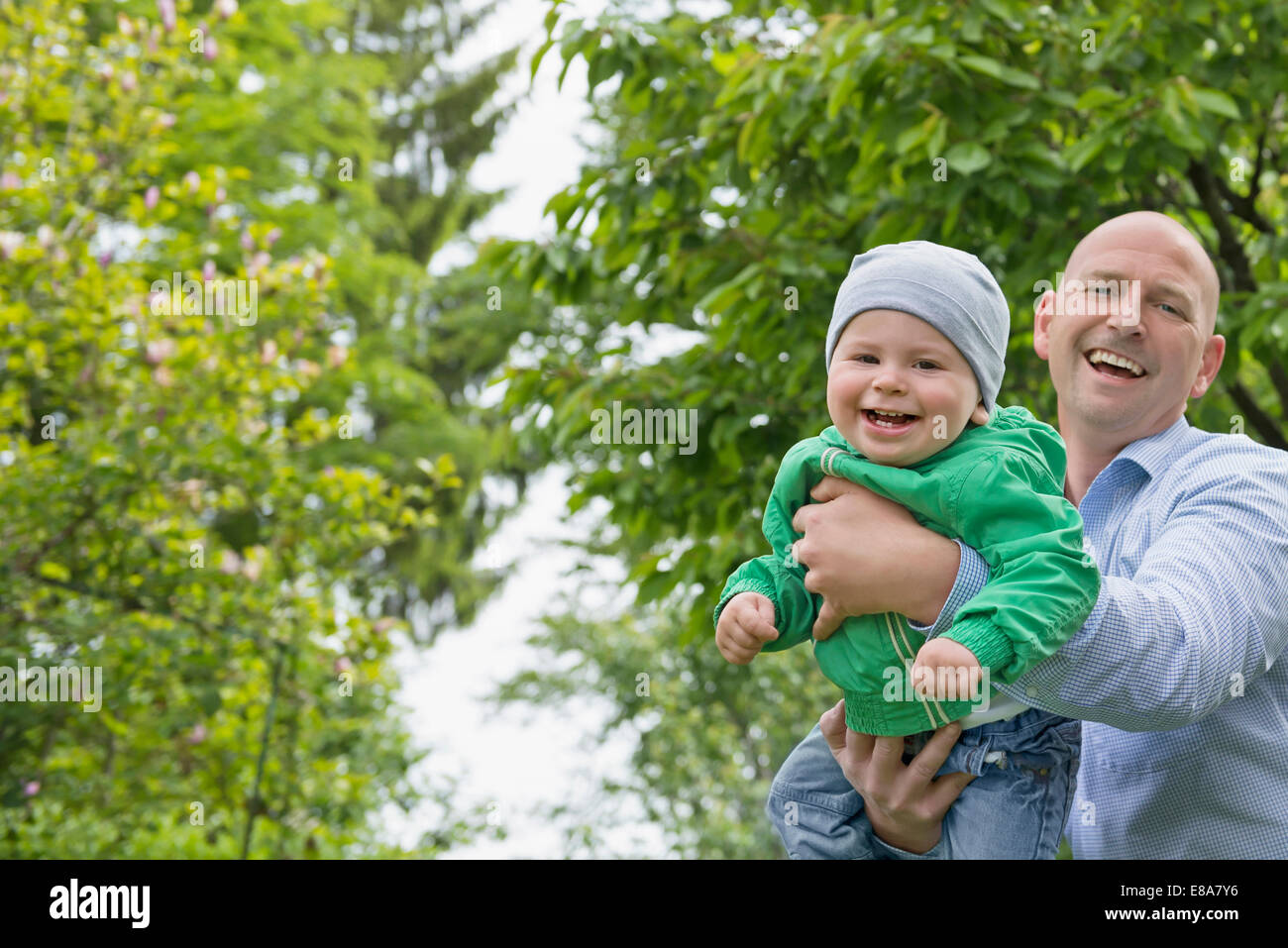 Father holding baby boy in arms playing flying Stock Photo - Alamy