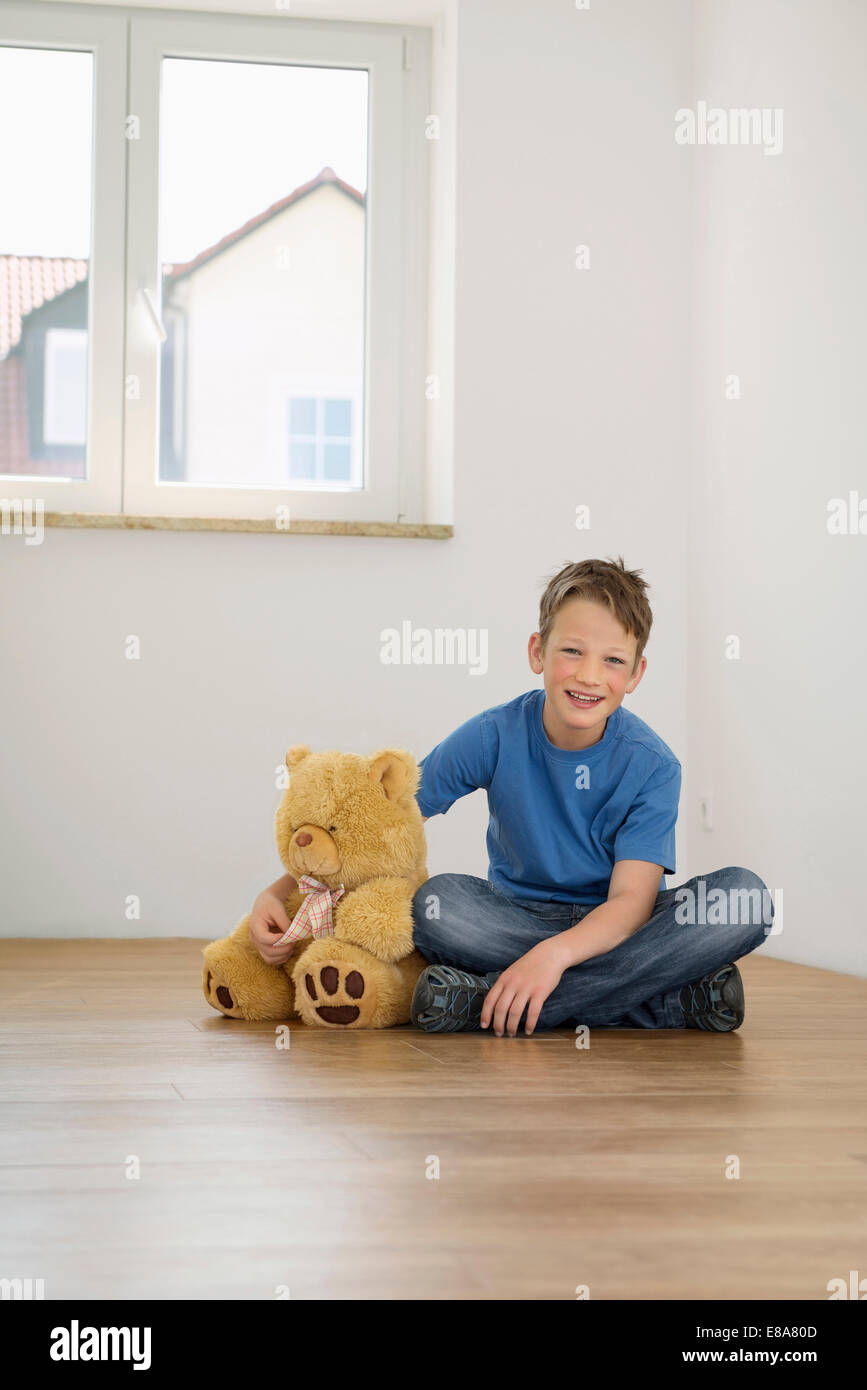 Young boy alone empty room teddy moving home Stock Photo - Alamy