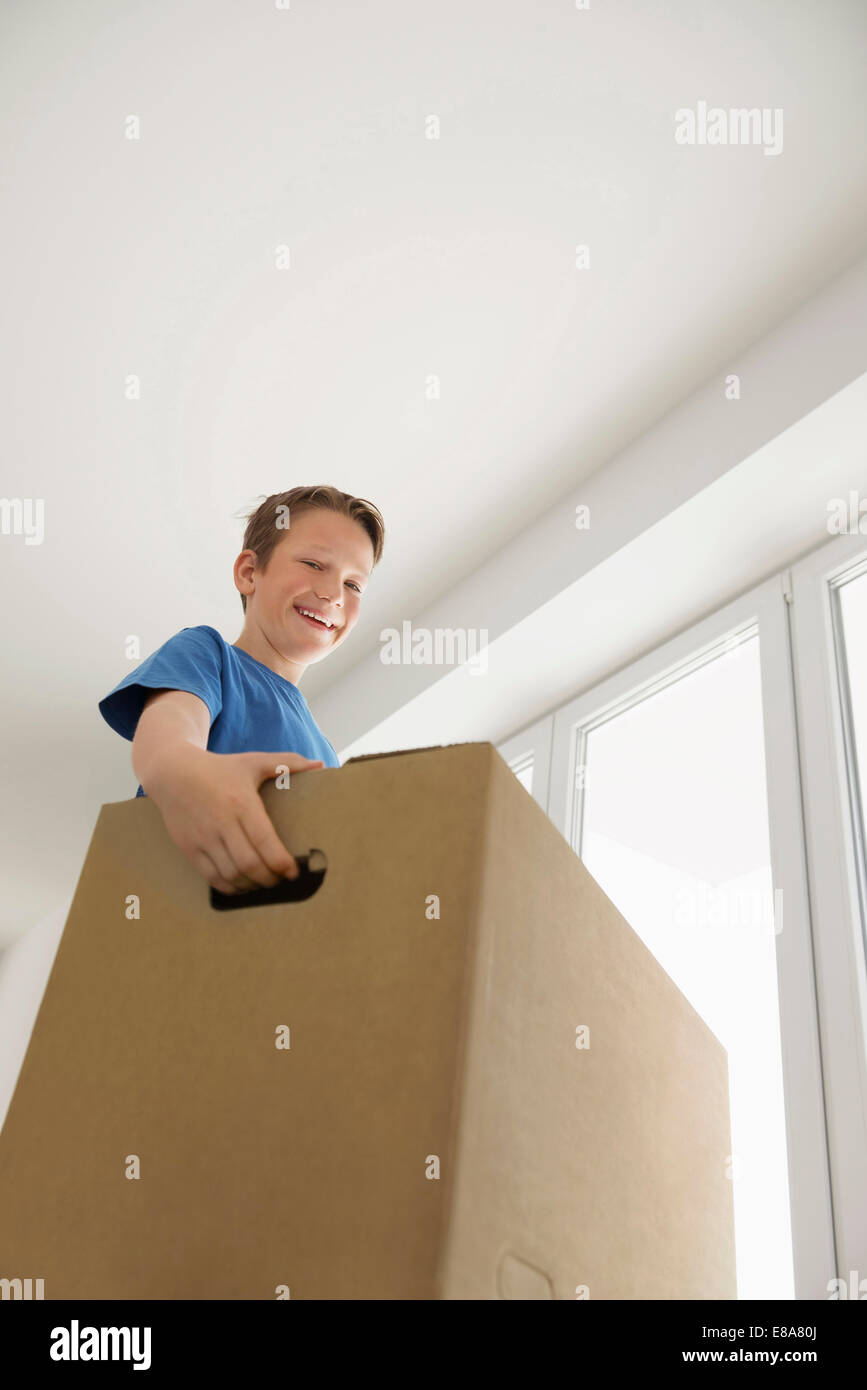 Young boy carrying big cardboard box new home Stock Photo - Alamy