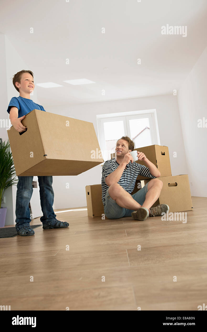 Father son moving house carrying packing case Stock Photo - Alamy