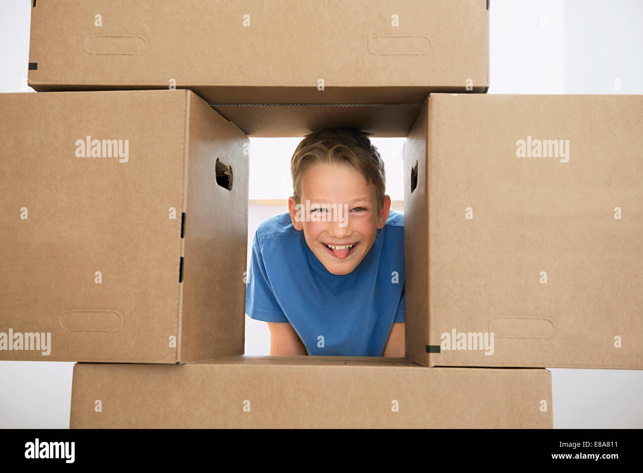 Boy building pile cardboard boxes in new home Stock Photo - Alamy