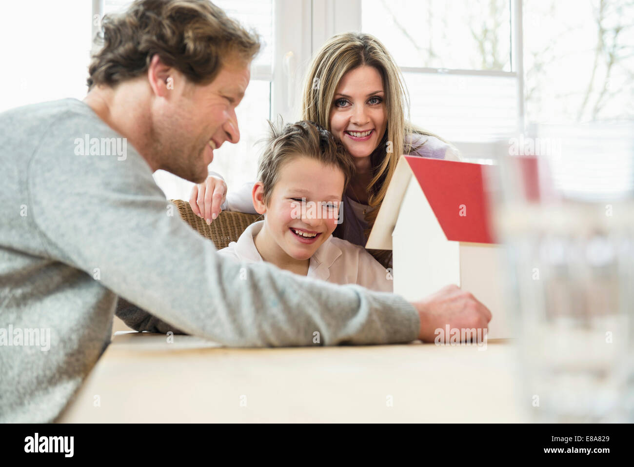 Family with architectural model at table Stock Photo - Alamy
