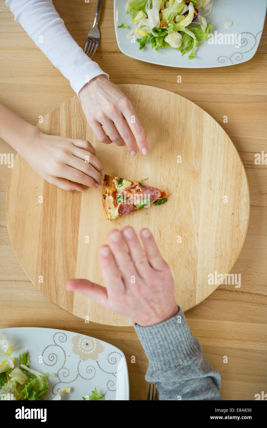 Family fighting for last slice of pizza Stock Photo - Alamy