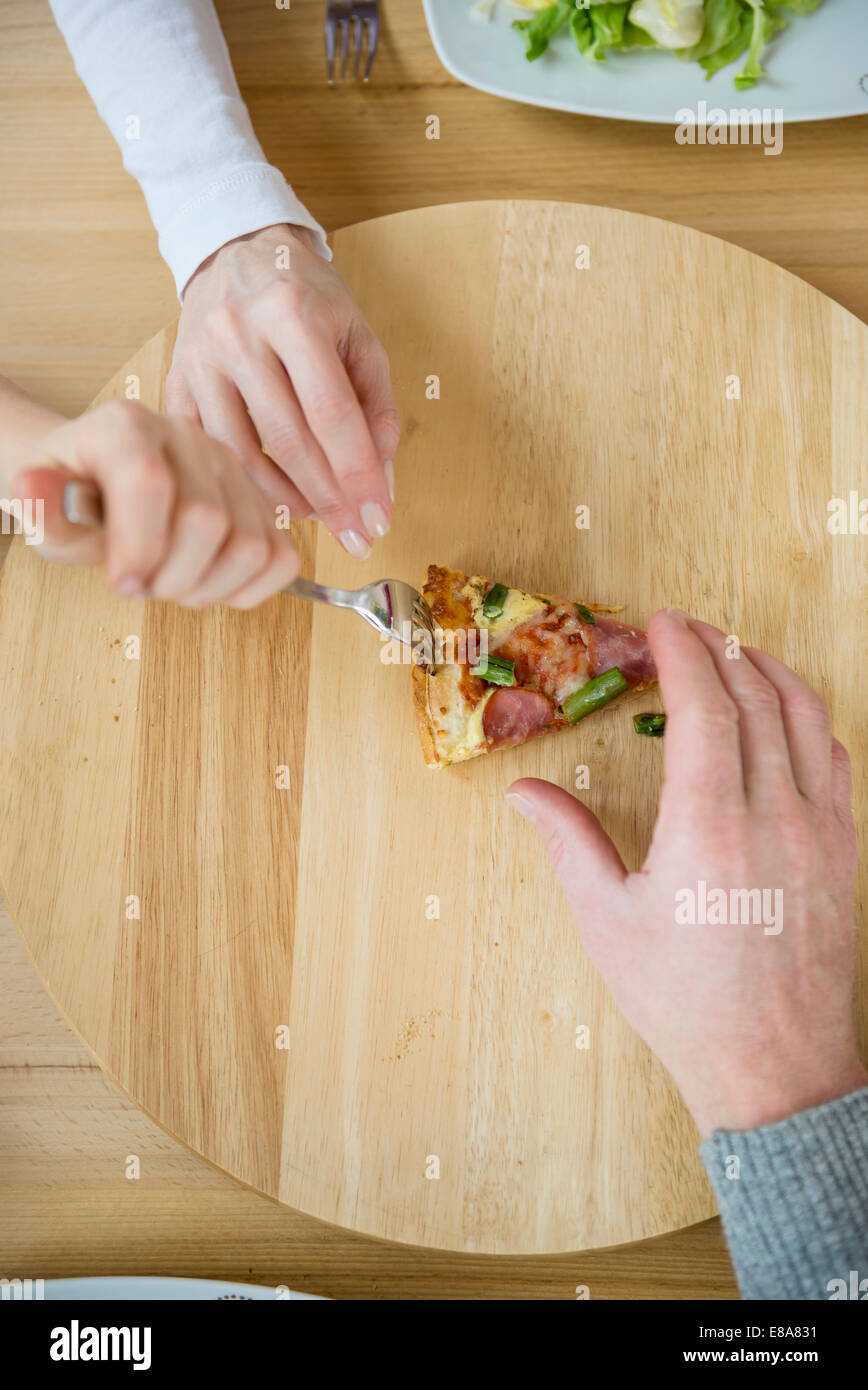 Family fighting for last slice of pizza Stock Photo - Alamy