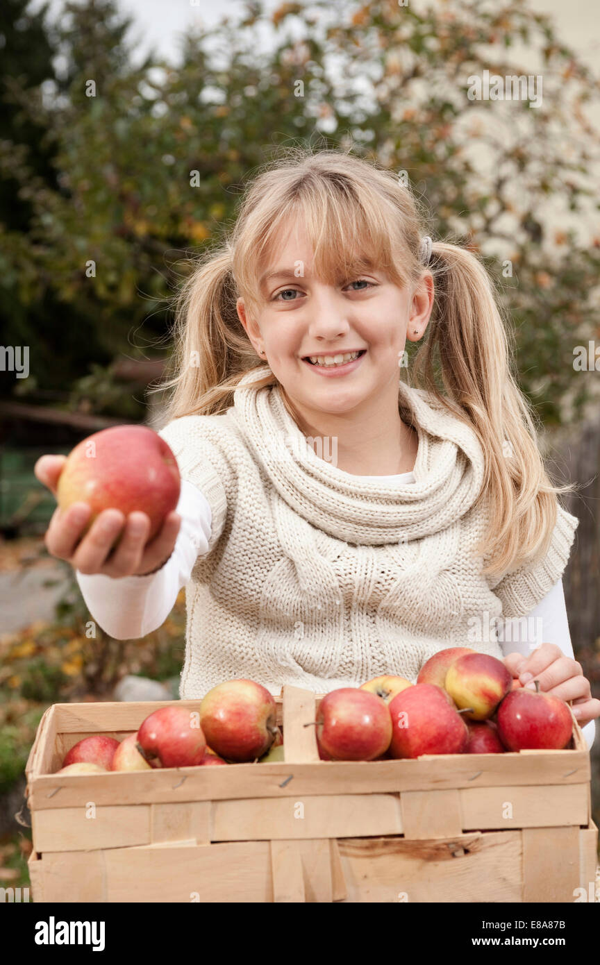Blond girl holding an apple Stock Photo - Alamy