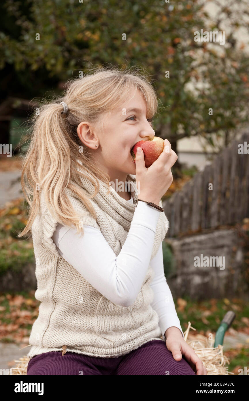 Blond girl eating an apple Stock Photo - Alamy