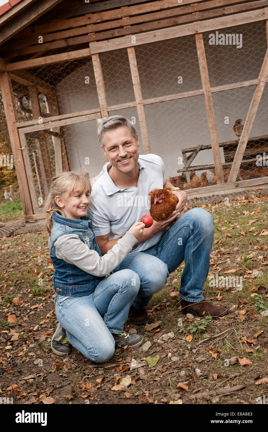 Father and daughter with chicken on organic farm Stock Photo - Alamy
