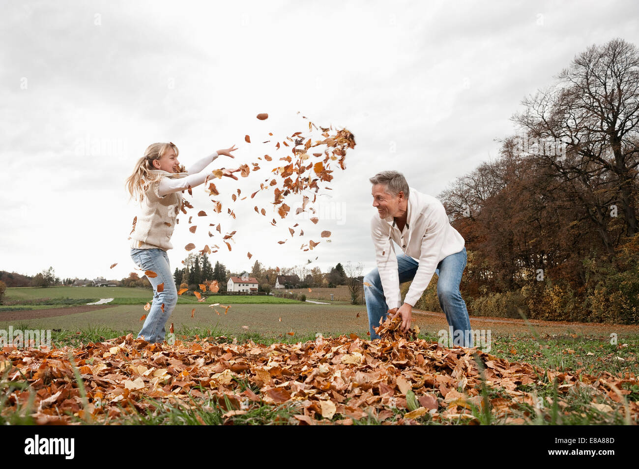 Happy girl with father throwing autumn leaves Stock Photo - Alamy
