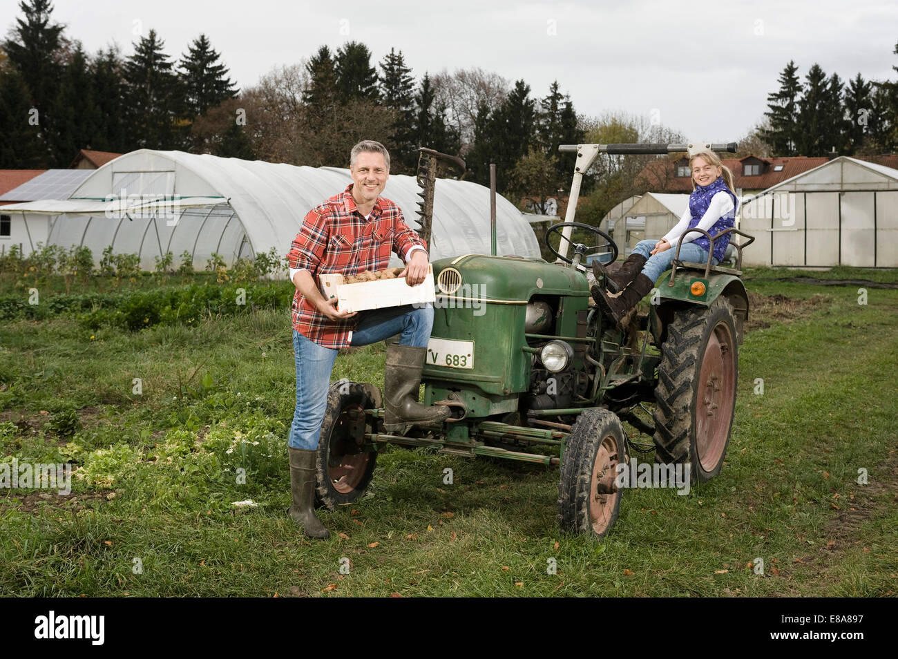 Farmer with daughter on tractor Stock Photo - Alamy