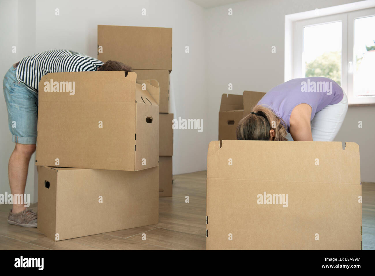 Couple man woman looking inside cardboard boxes Stock Photo - Alamy