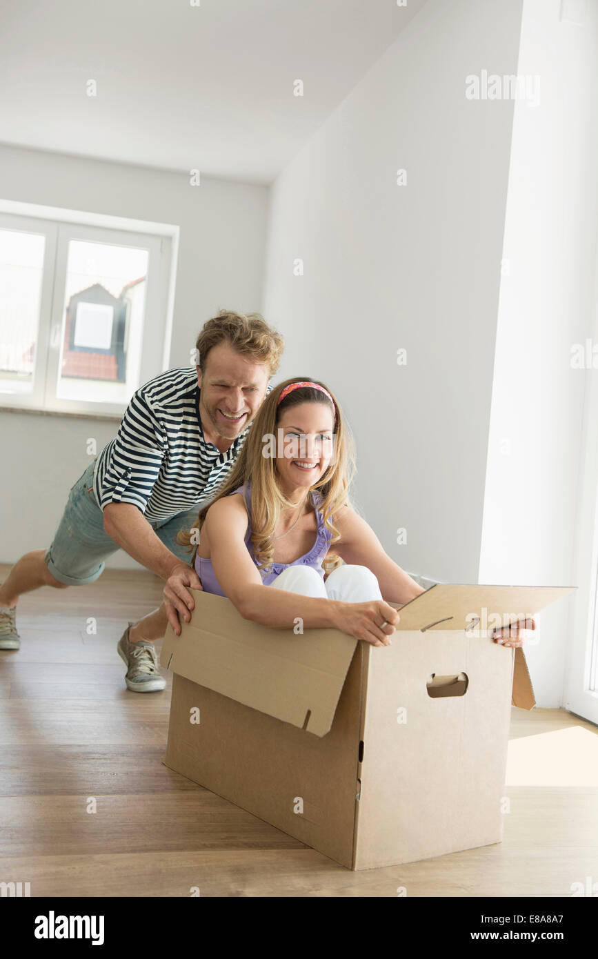 Man pushing woman inside box new home Stock Photo - Alamy