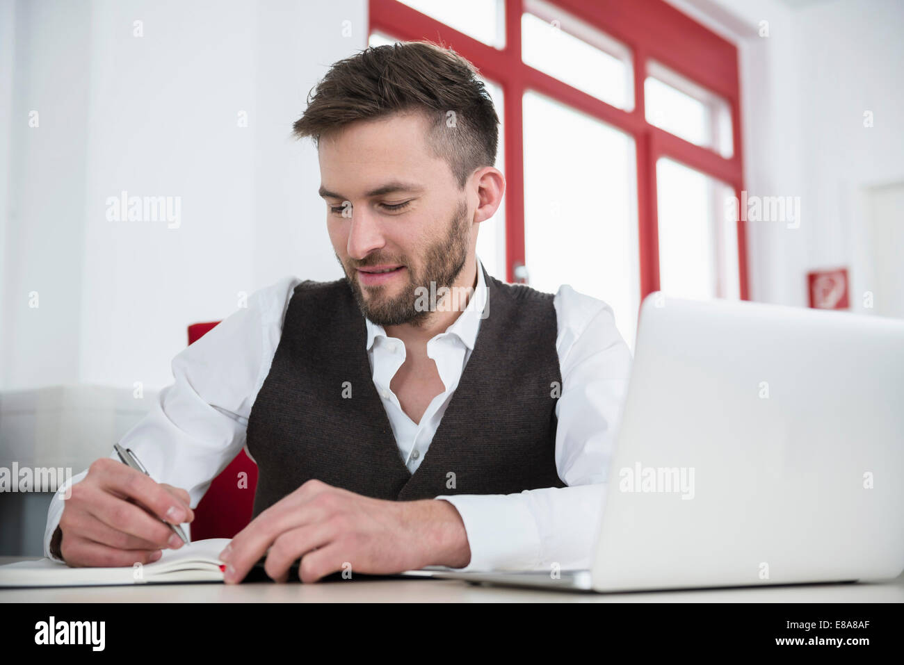 Working at his desk looking at notice hi-res stock photography and ...