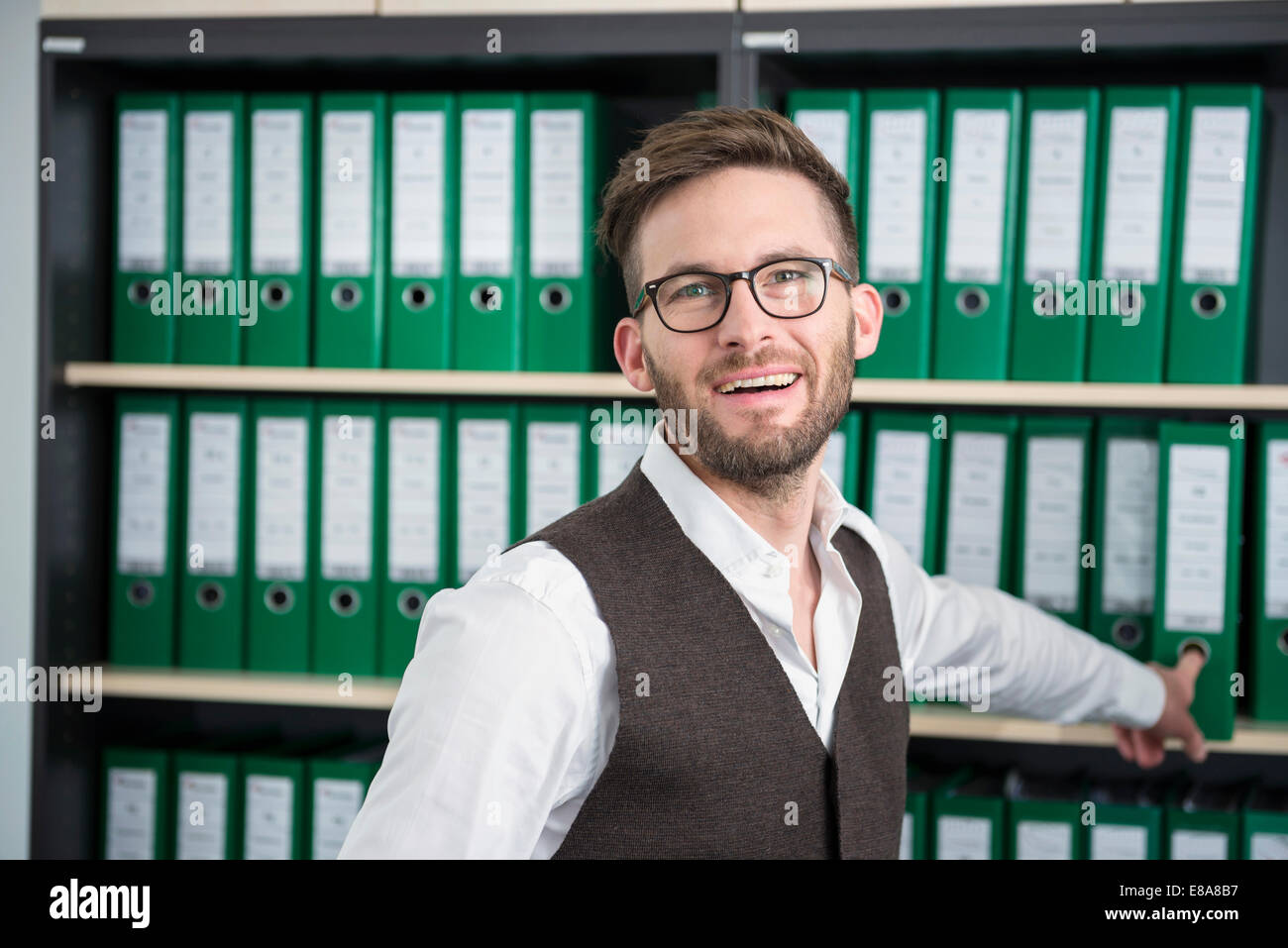Man young office shelves filing cabinet smiling Stock Photo - Alamy