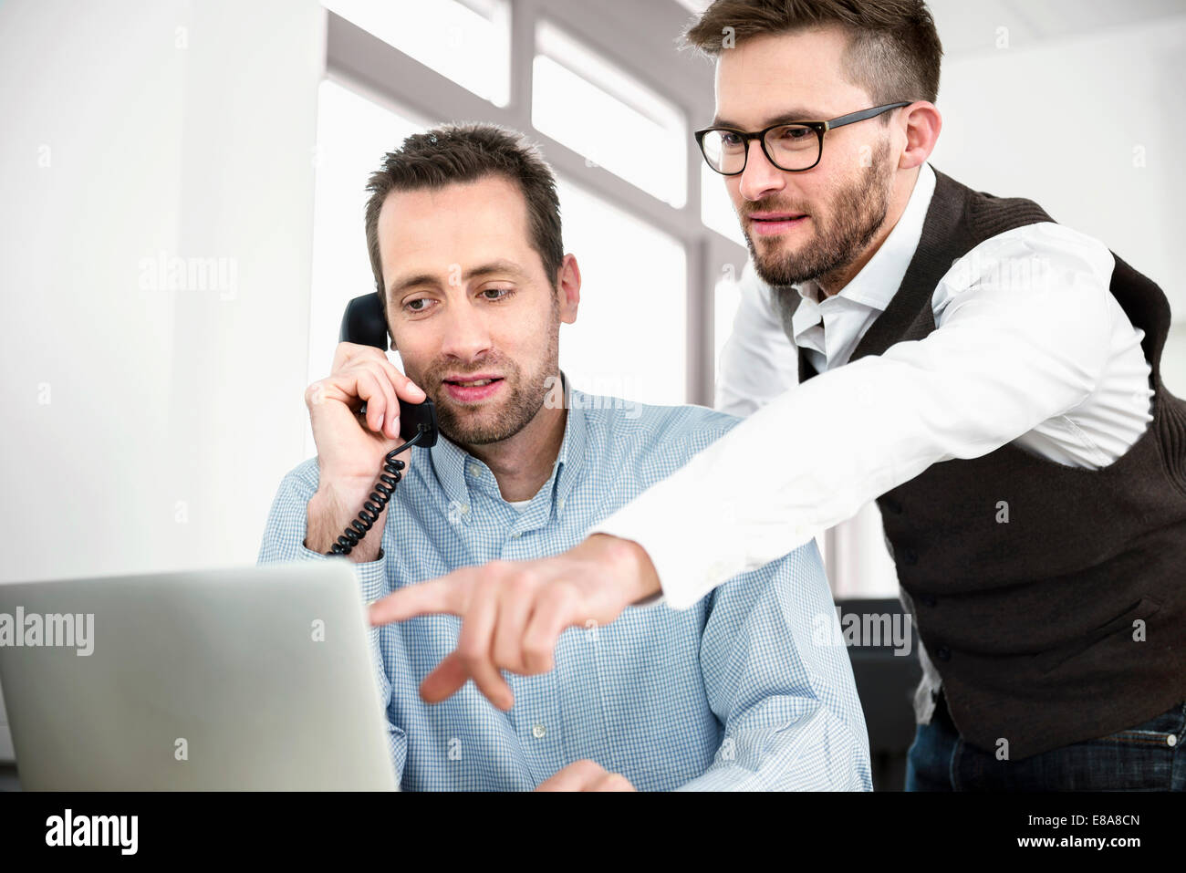 Two men telephone talking computer meeting Stock Photo - Alamy