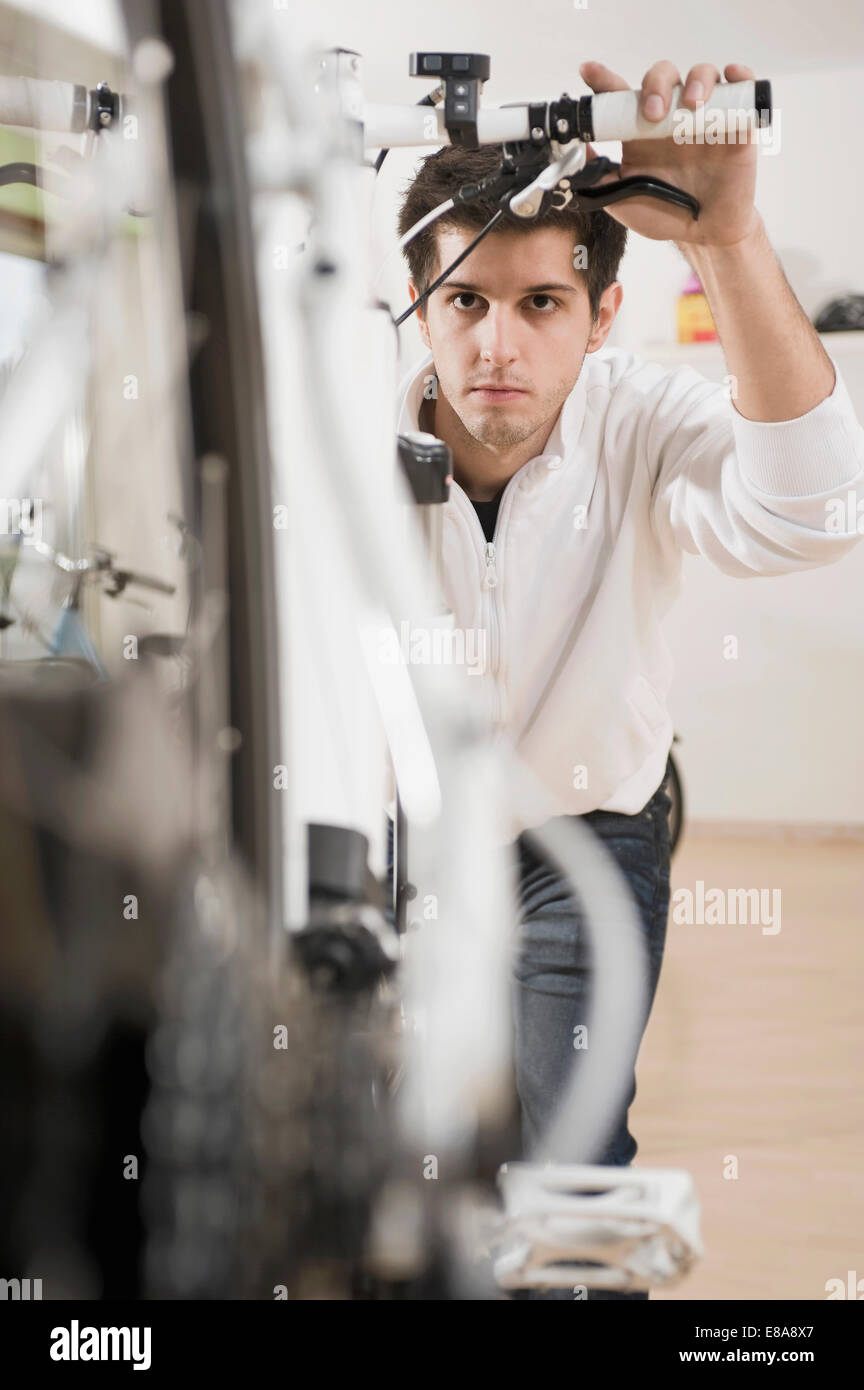 Young man working on bicycle Stock Photo - Alamy