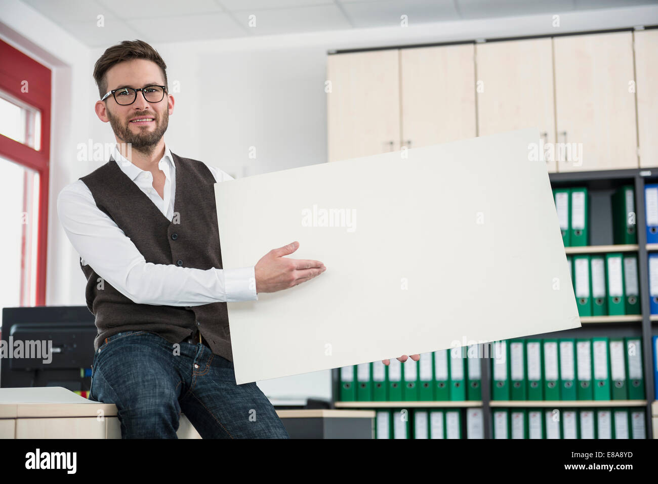 Young man office holding poster sign advert Stock Photo - Alamy