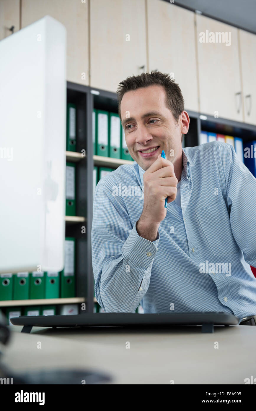 Young man sitting office working computer Stock Photo - Alamy