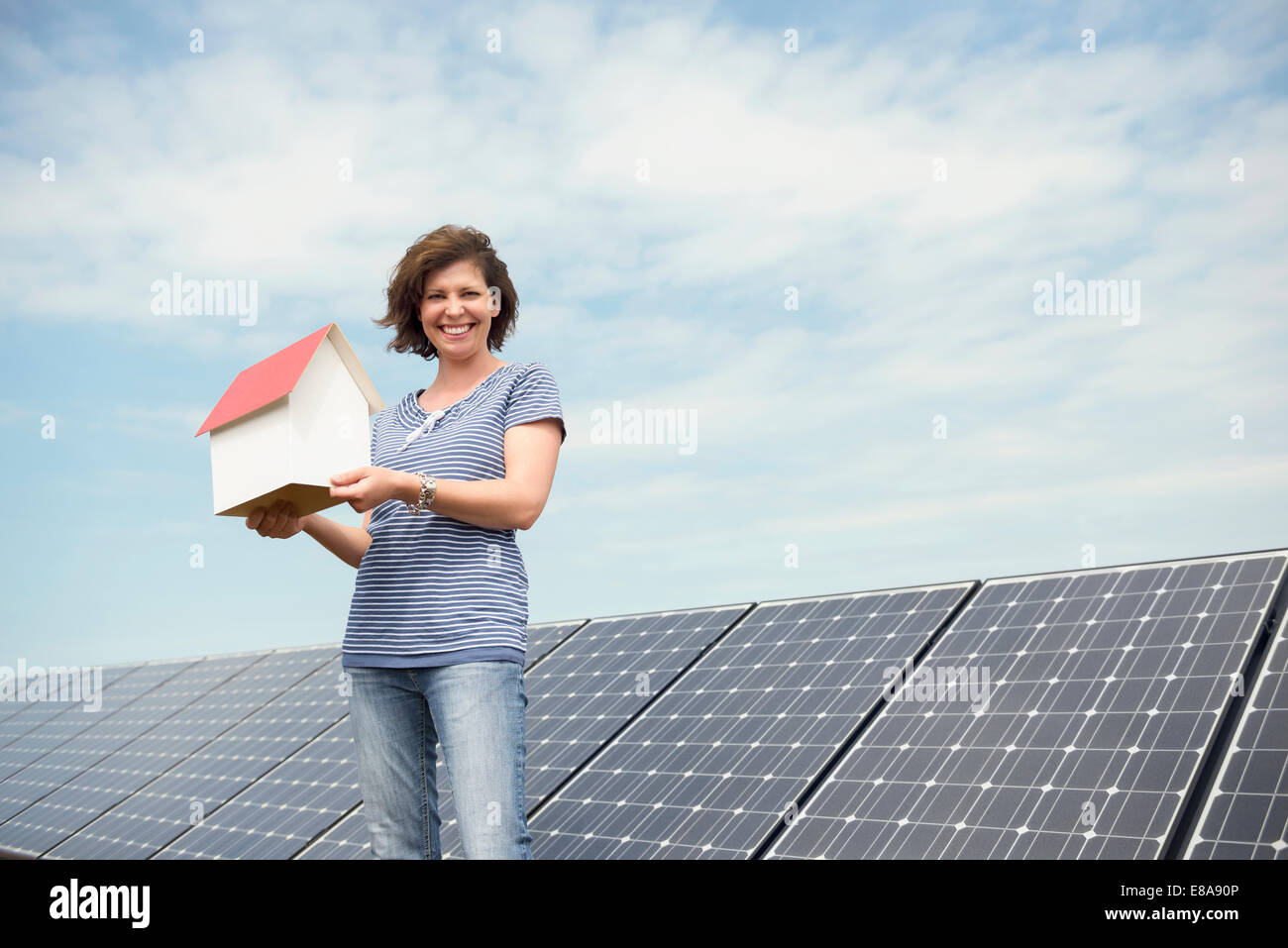 Woman holding small model house solar energy Stock Photo - Alamy