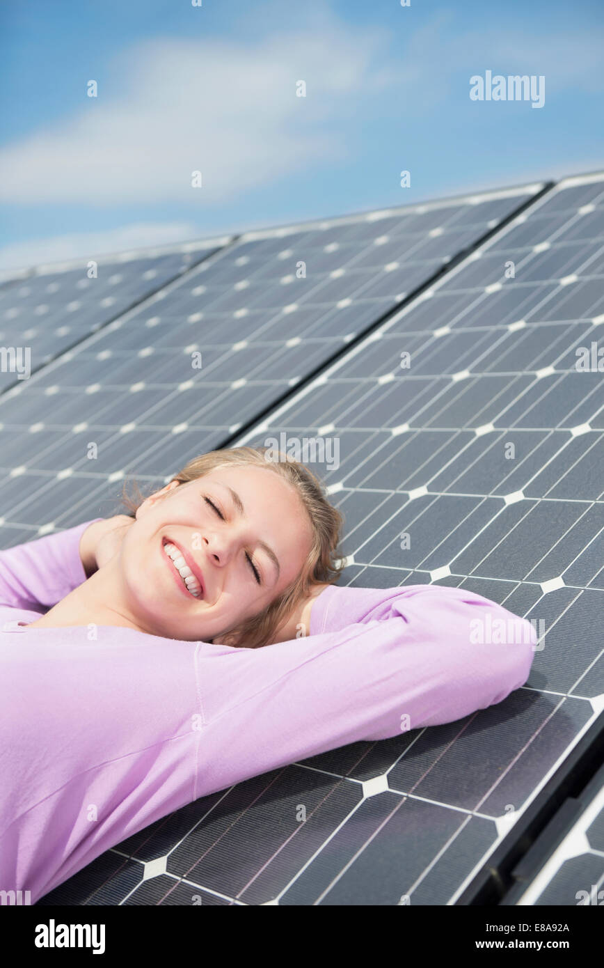 Relaxing happy green energy girl solar panel Stock Photo - Alamy