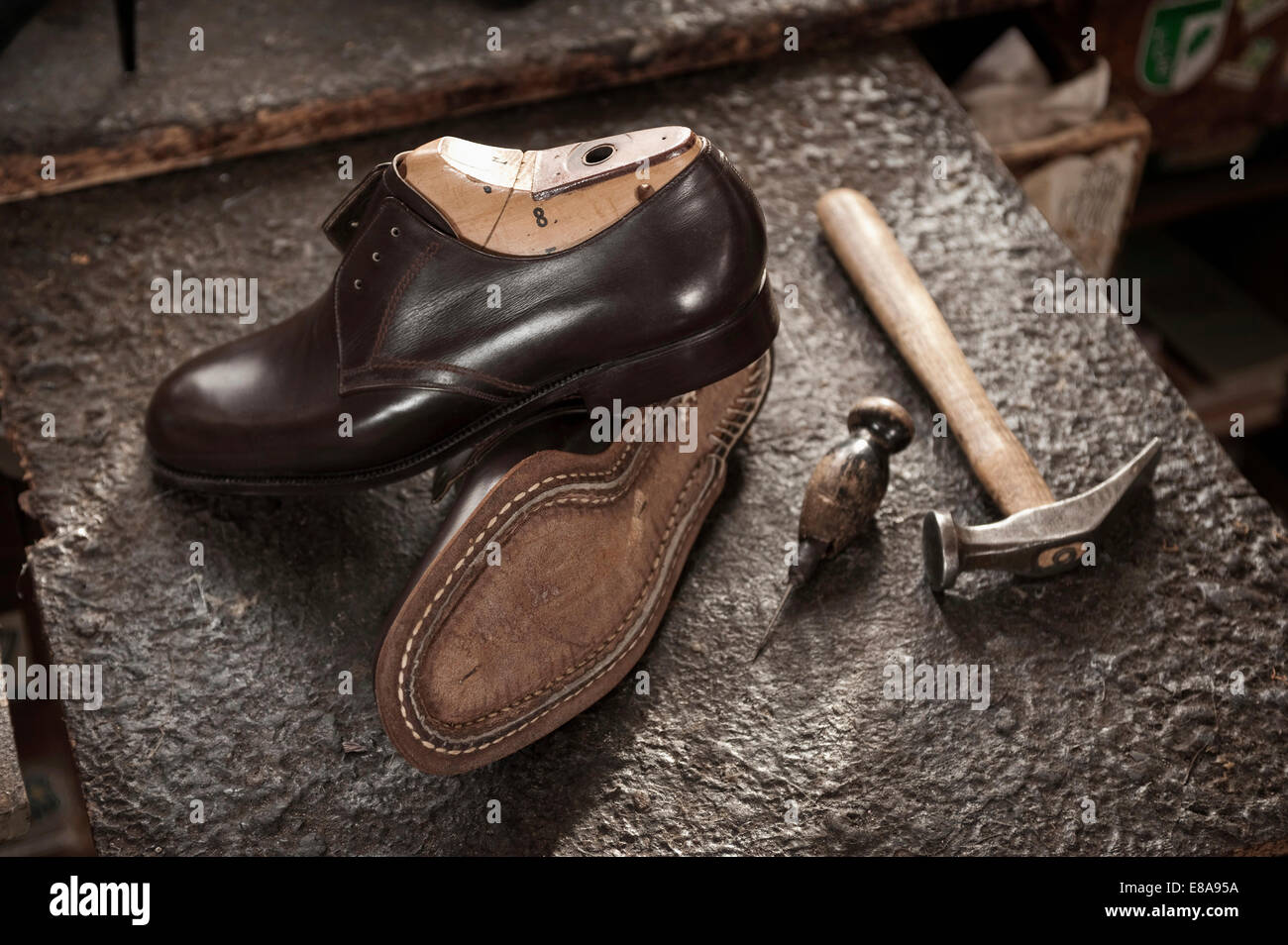 Pair of leather shoes, awl and hammer in a cobbler's shop Stock Photo ...