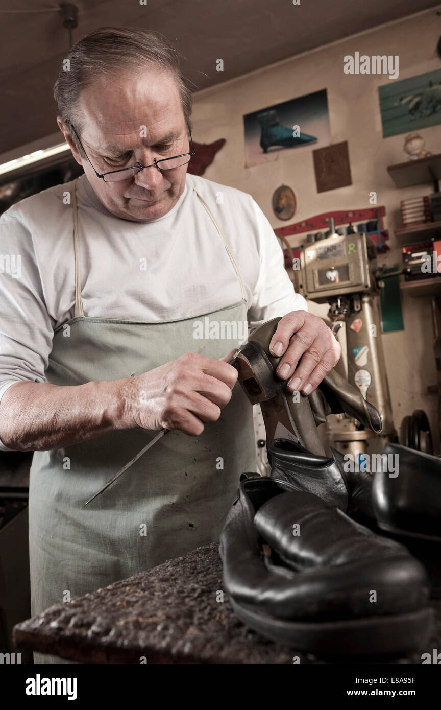 Cobbler working in workshop Stock Photo - Alamy