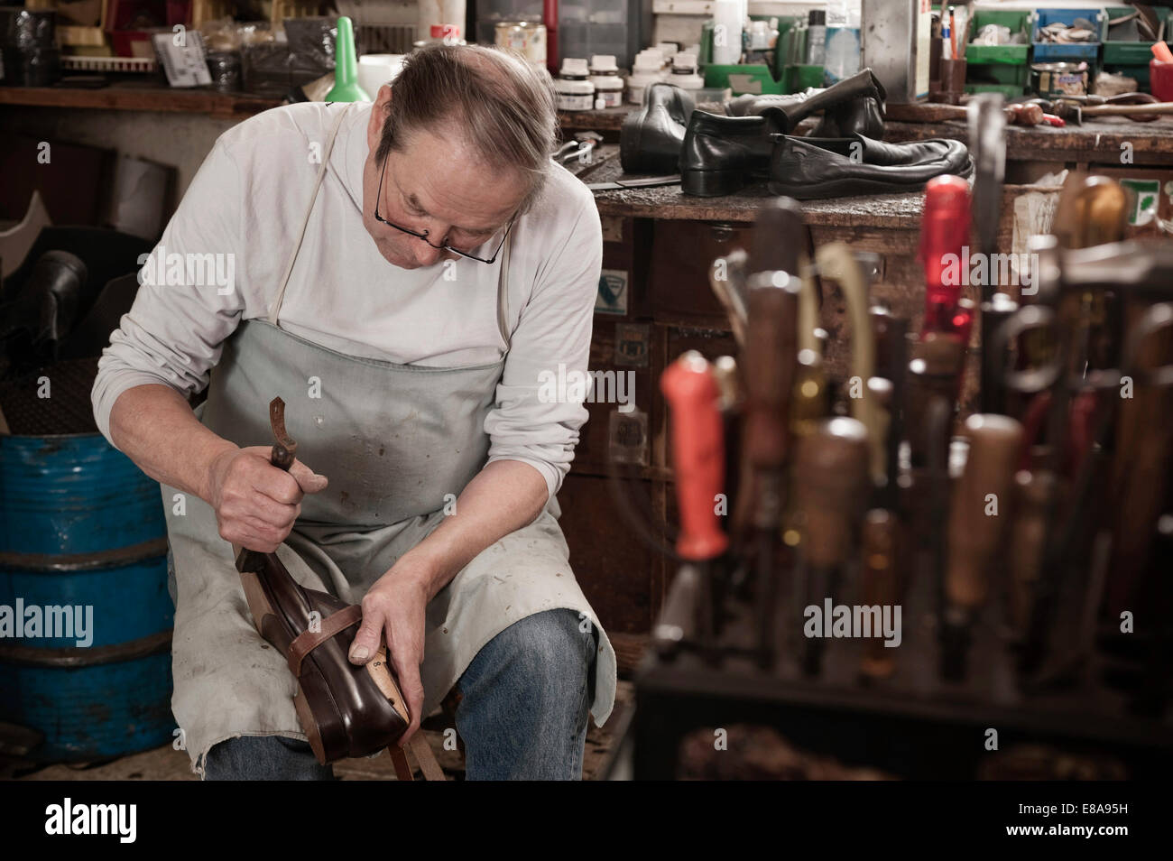 Cobbler working in workshop Stock Photo - Alamy