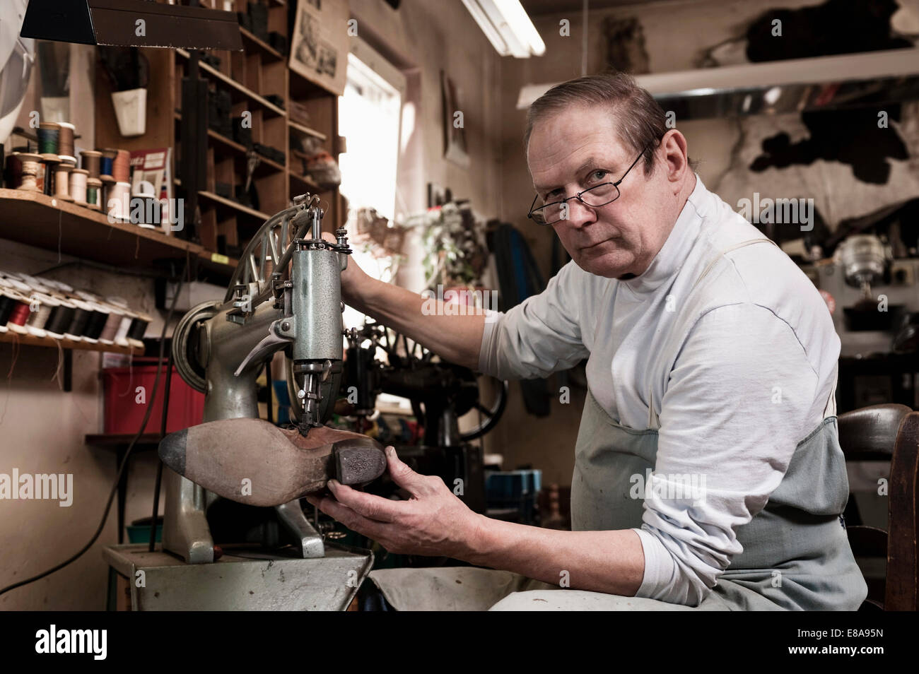 Cobbler working in workshop Stock Photo - Alamy