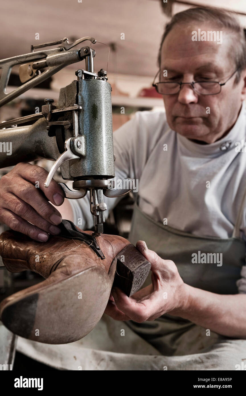 Cobbler working in workshop Stock Photo - Alamy