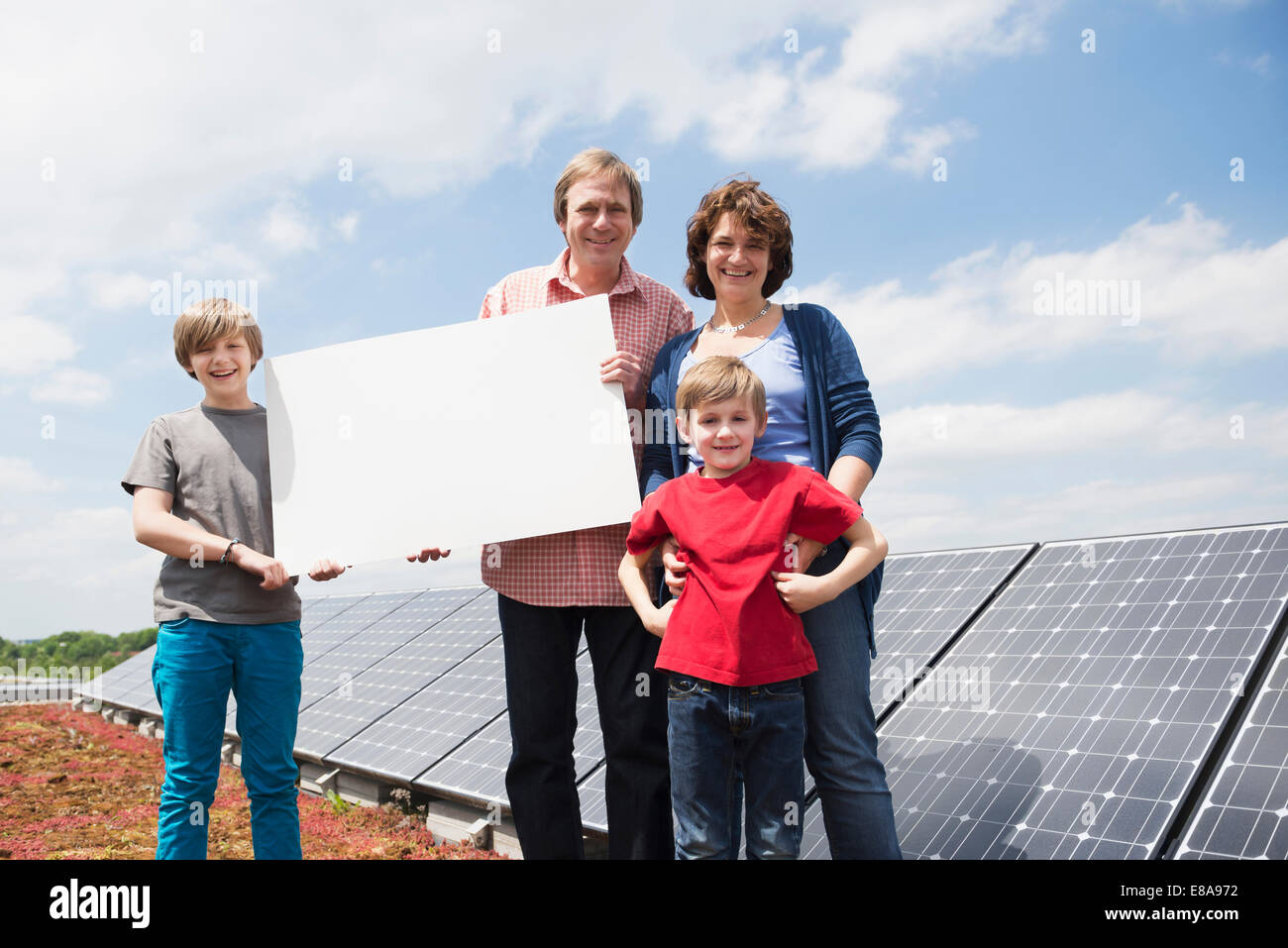 Family holding sign father mother boys kids Stock Photo - Alamy