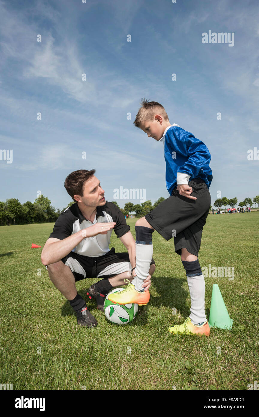 Soccer trainer testing young player helping Stock Photo - Alamy