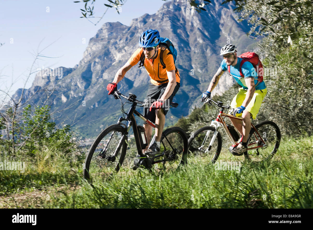 Men racing electic-mountainbikes mountain track Stock Photo - Alamy