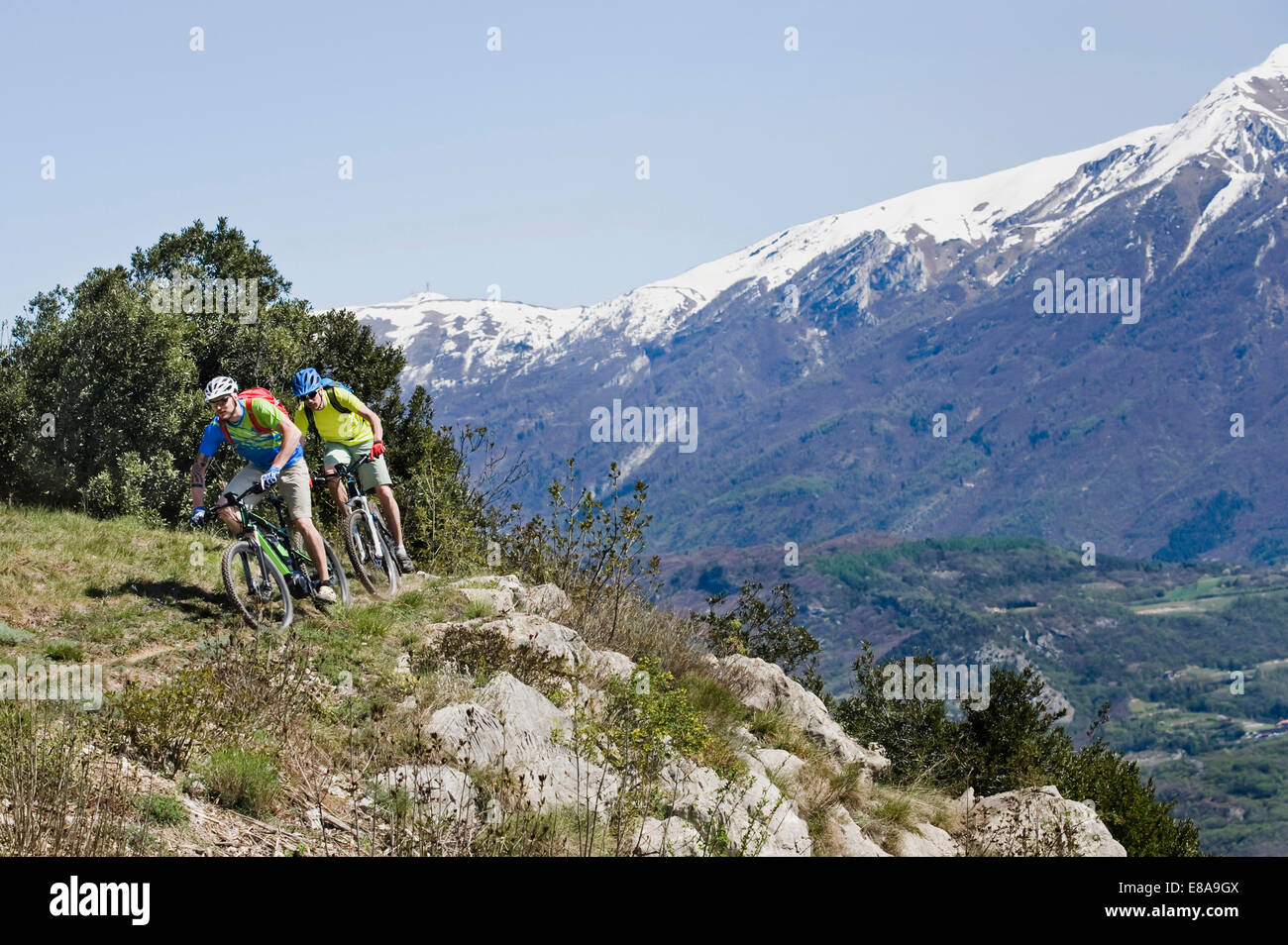 Two men racing electic-mountainbikes cliff Stock Photo - Alamy
