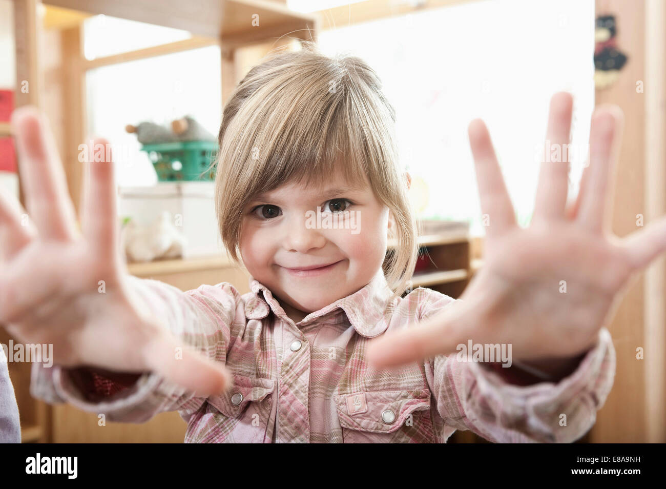 Portrait of smiling little girl showing her hands Stock Photo - Alamy