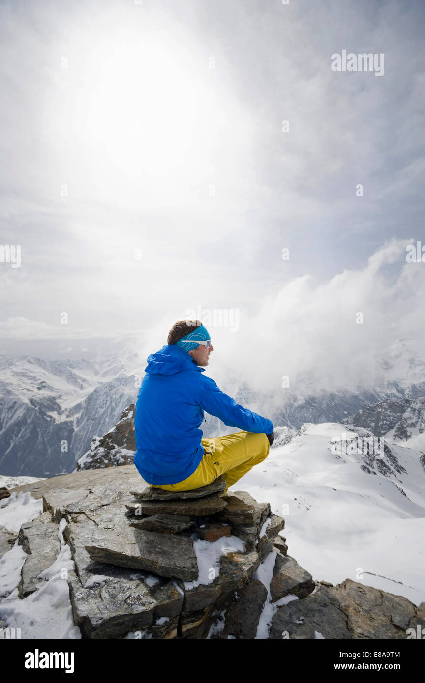 Man sitting contemplating mountain peak winter Stock Photo - Alamy