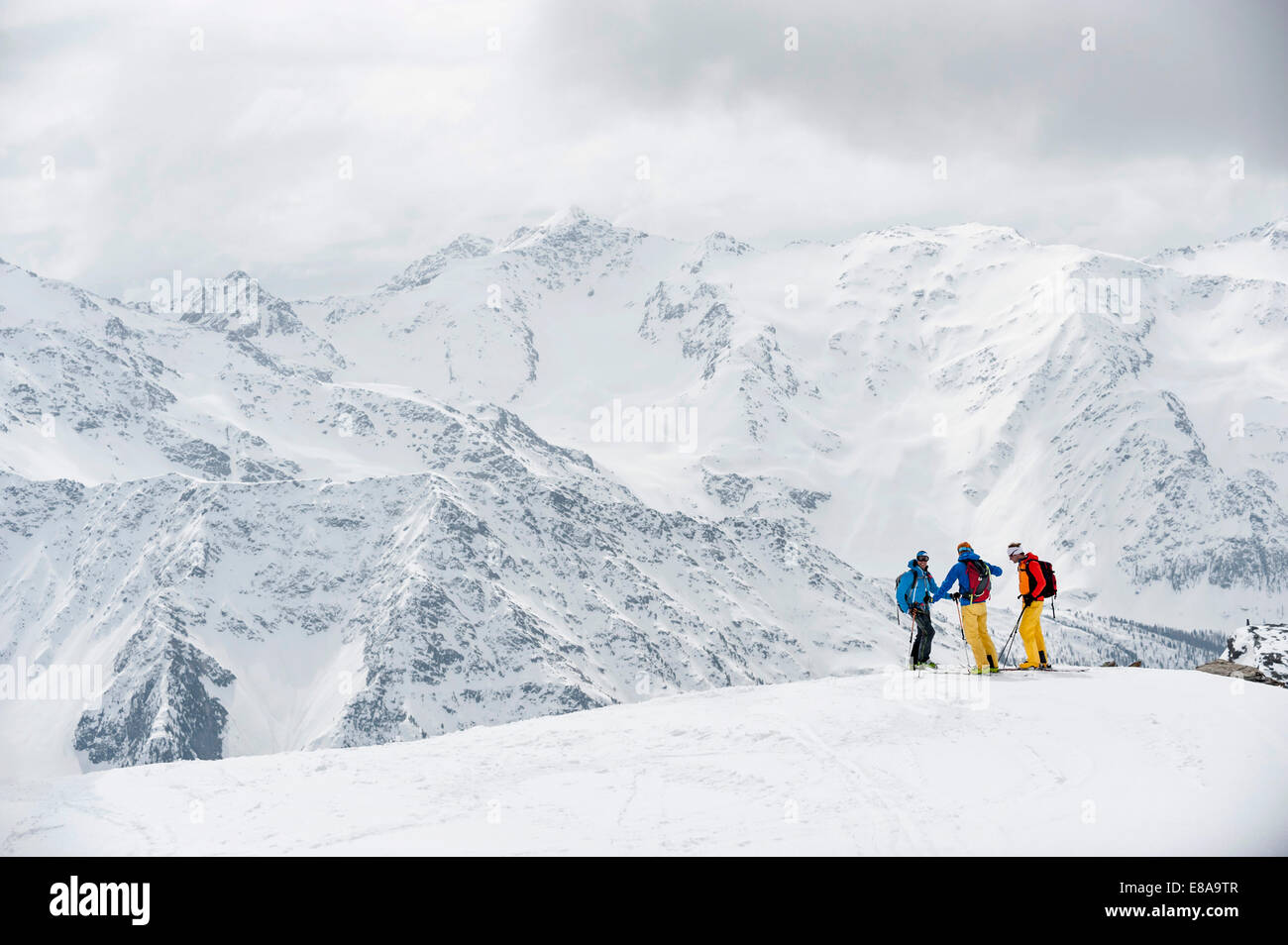 Alps winter mountains three skiers snow Stock Photo - Alamy