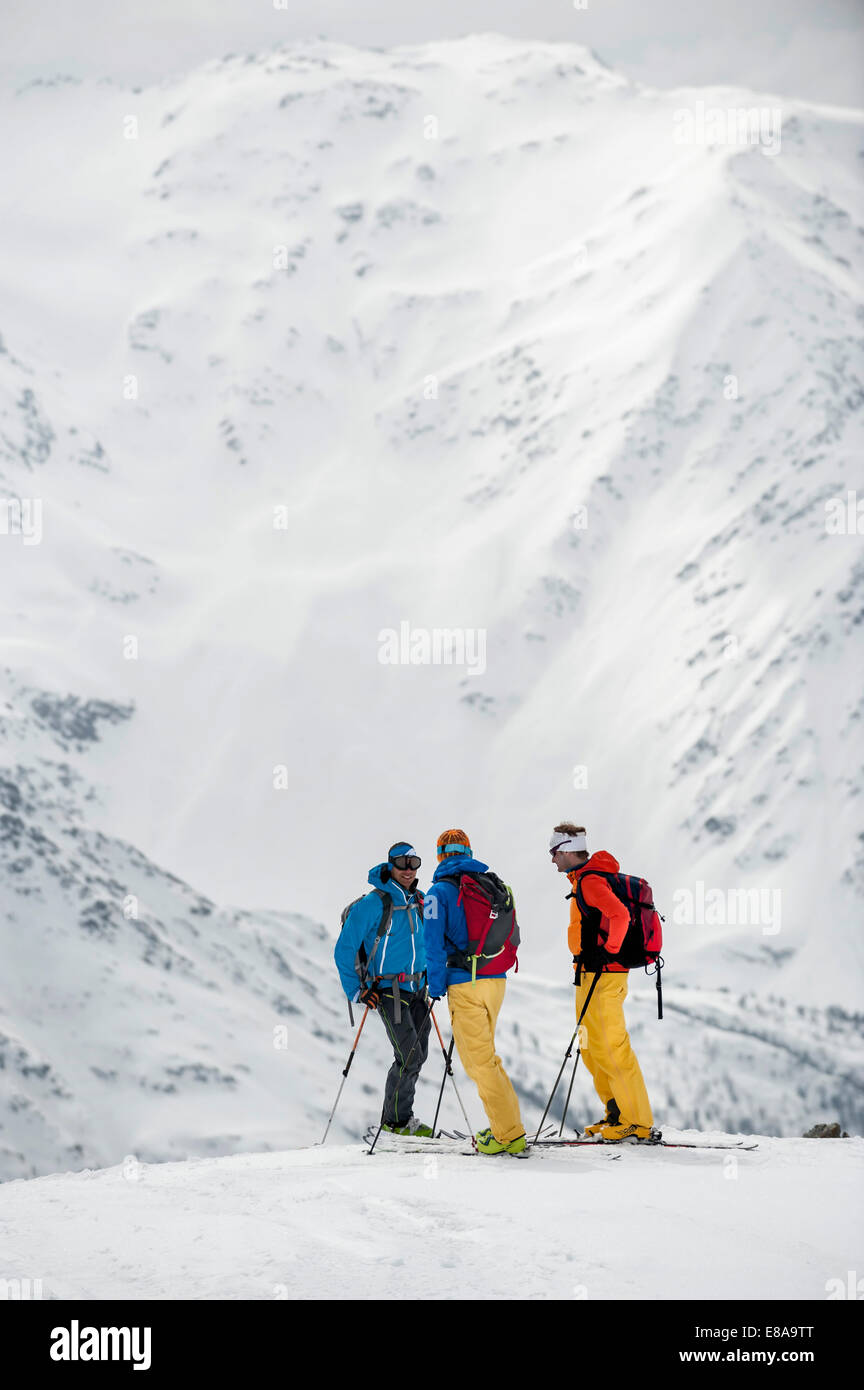 Three skiers winter snow standing mountains Stock Photo - Alamy
