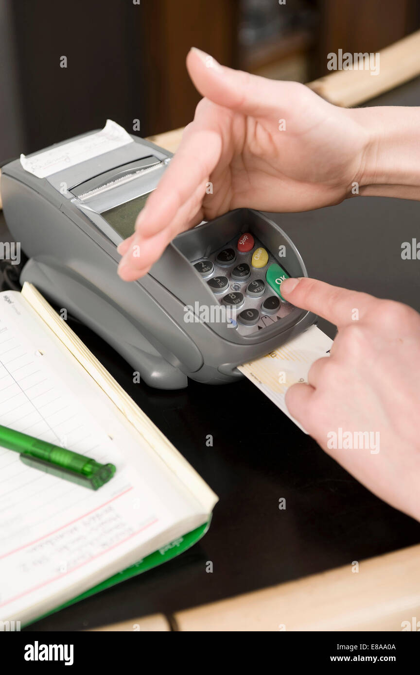 Young woman entering pin in credit card reader Stock Photo - Alamy