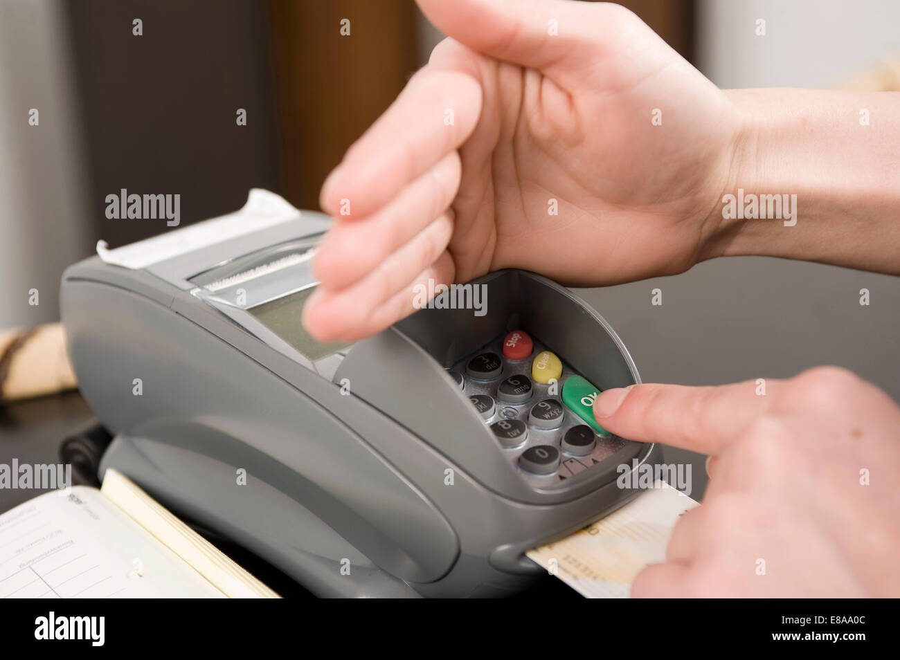 Young woman entering pin in credit card reader Stock Photo - Alamy