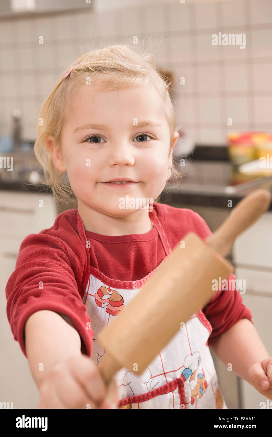 Girl holding rolling pin, smiling, portrait Stock Photo - Alamy