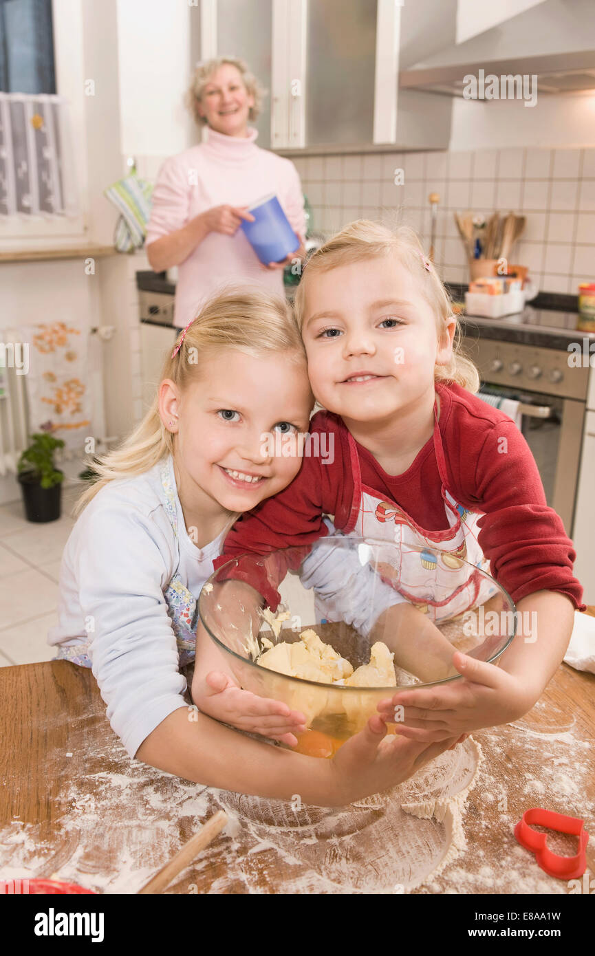 Family preparing cookies in kitchen, smiling Stock Photo - Alamy