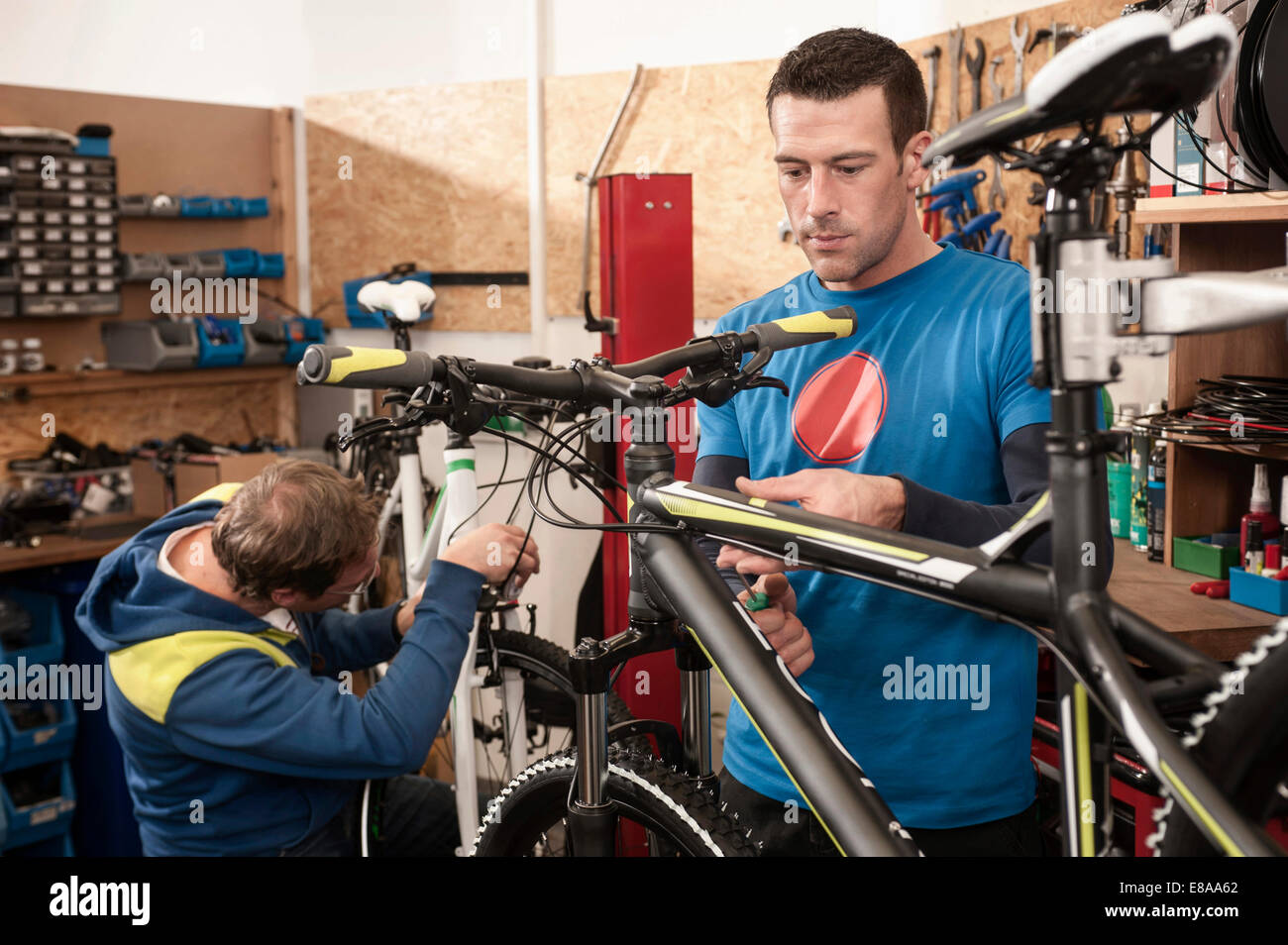 Men repairing bicycle in workshop Stock Photo - Alamy